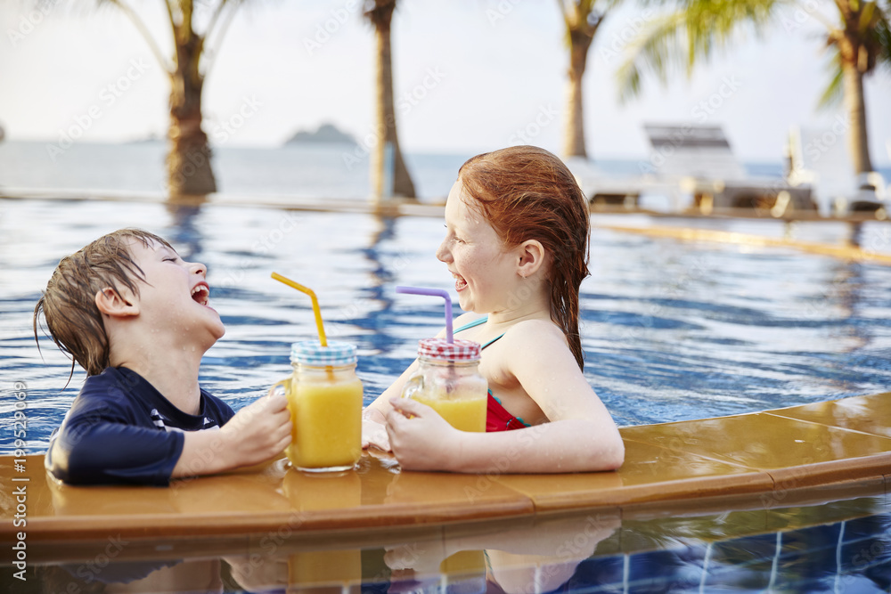 Happy boy and girl in swimming-pool Stock Photo | Adobe Stock