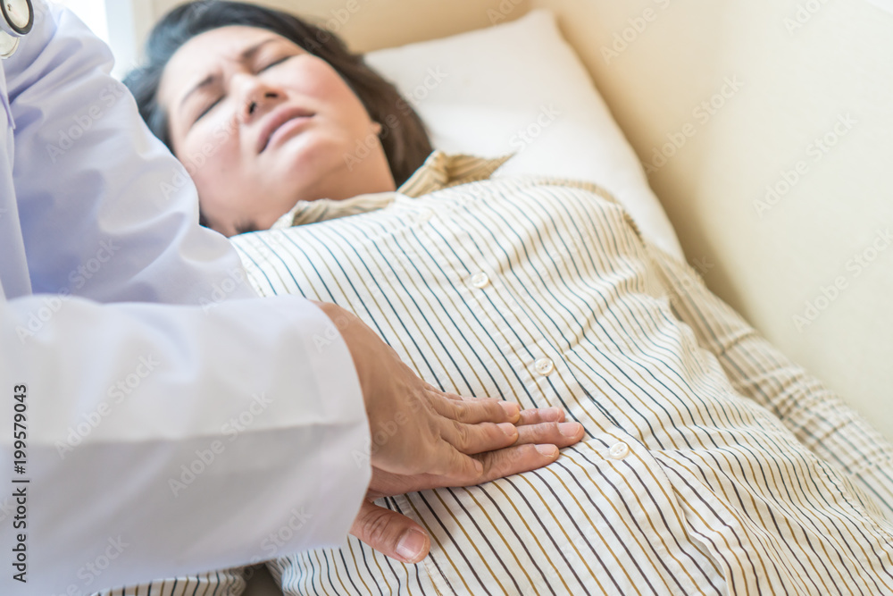 Doctor examining stomach of woman patient and pressing hands on her ...