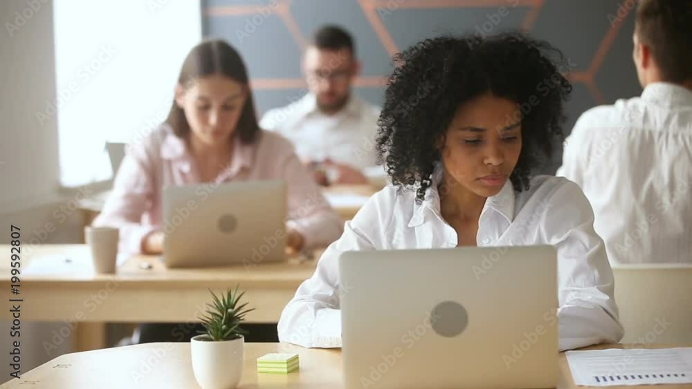 African american businesswoman working on laptop and document in ...