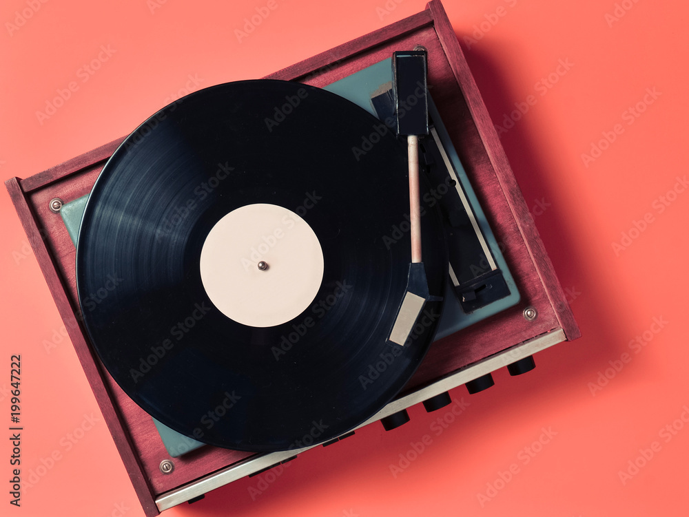 Vintage vinyl turntable with vinyl plate on an orange pastel background ...