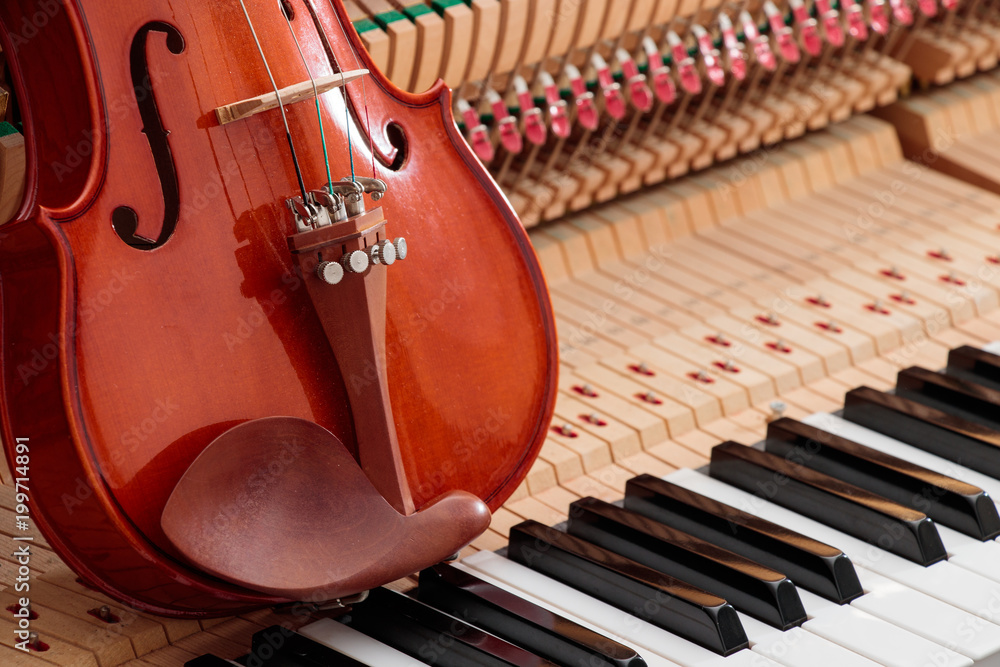 classic brown violin on the close up image of grand piano keys and ...