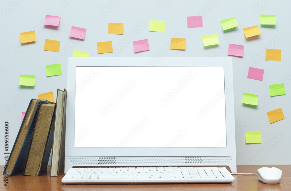 Desktop computer with blank white screen books and stickers on the ...