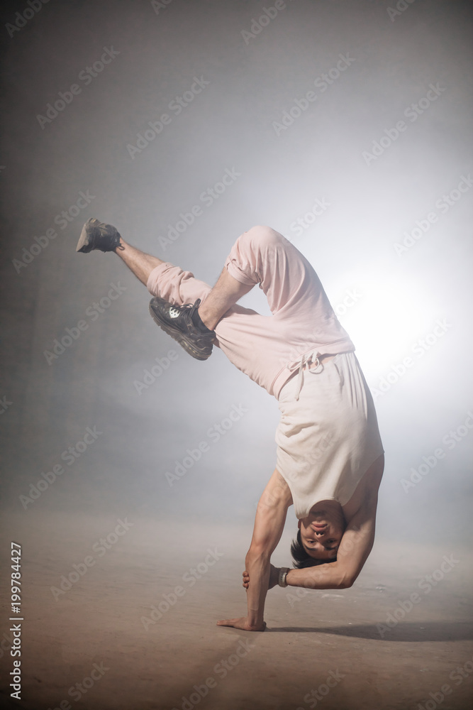man with strong muscles on arms doing upside down stunt. touching the ...
