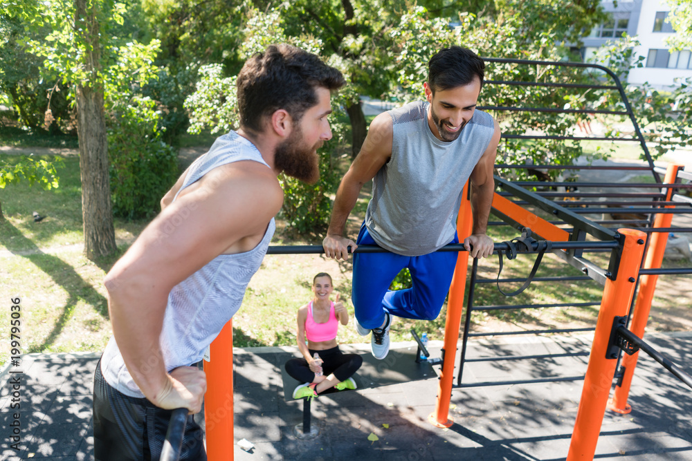 Two muscular young men doing bodyweight exercises for the upper-body ...