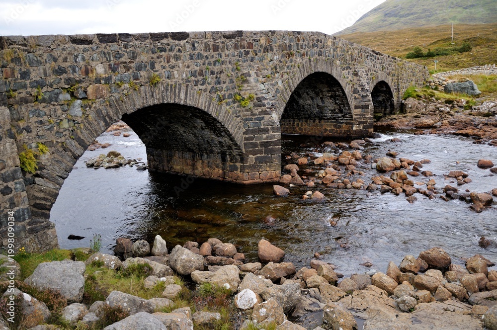 Old massive stone bridge crossing shallow river in Sligachan, Isle of ...