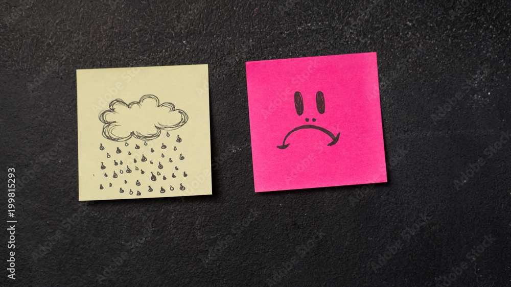 Sticky notes with sad face icon next to the rainy cloud drawning on the ...