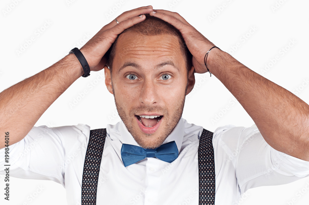 A young man in a white shirt with a short hair is surprised. White ...