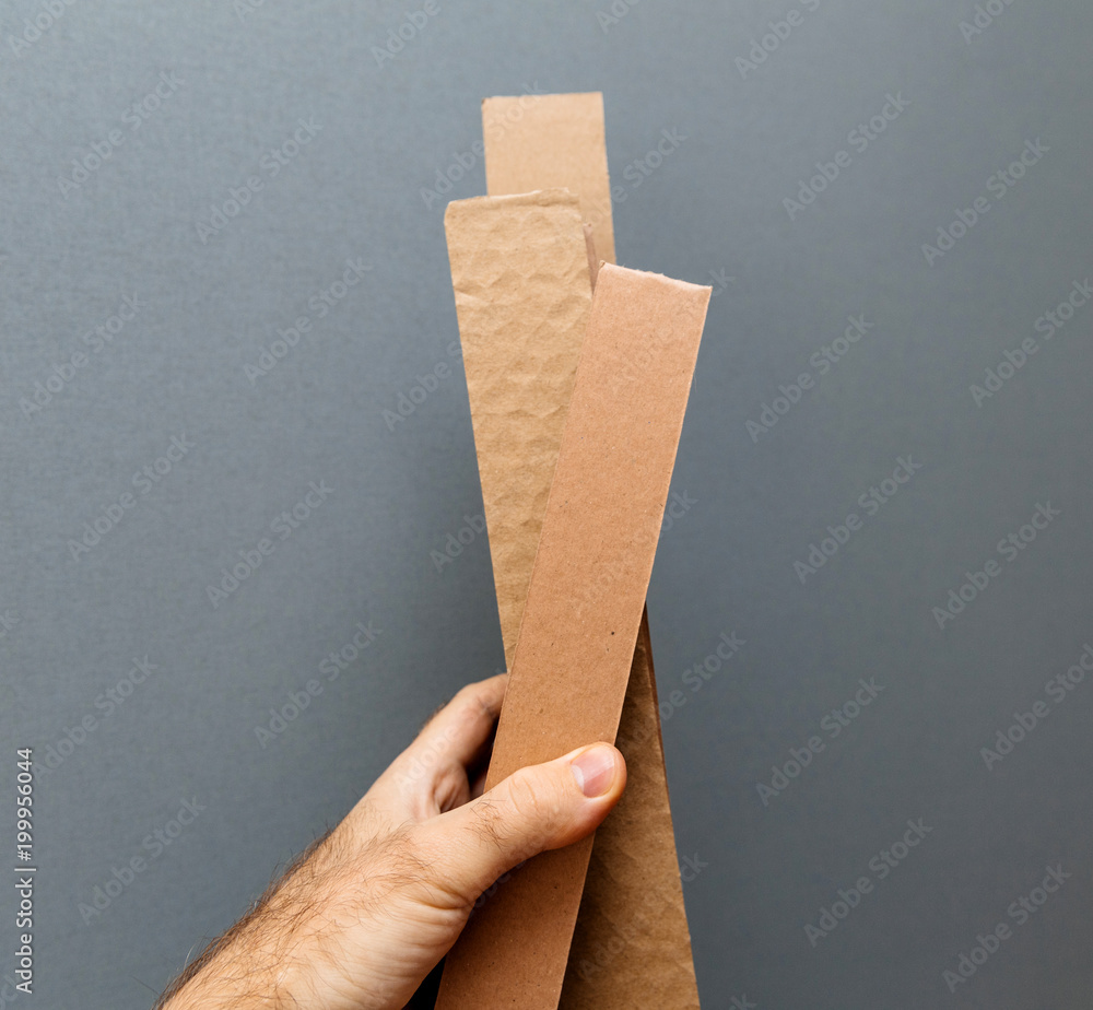 Factory worker male hand holding against gray background a stack of ...
