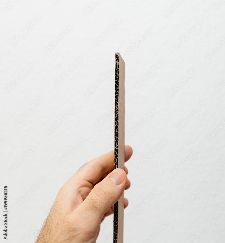 Factory worker male hand holding against white background a thin ...