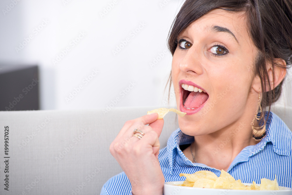 young brunette woman eating chips Stock Photo | Adobe Stock