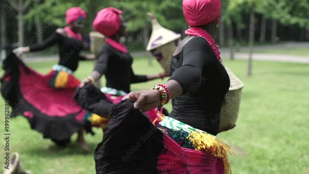 Three african women dancing folk dance in traditional costumes with ...