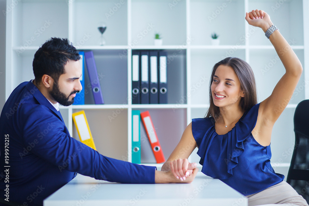 Side view portrait of man and woman armwrestling, exerting pressure on ...