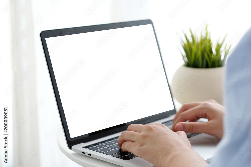 Man hands typing laptop computer with blank screen for mock up template ...