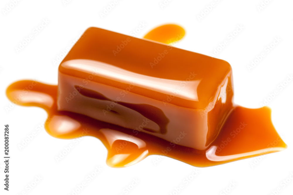 Caramel sauce flowing on caramel candies, isolated on white background ...