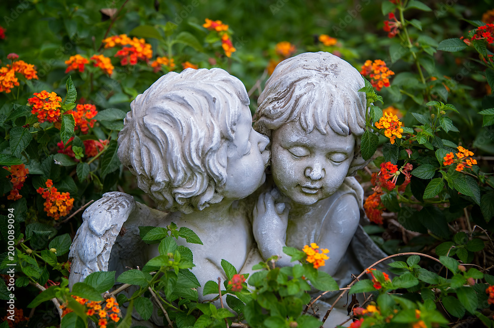 ANGELS IN LOVE. Sculptures of boy and girl angels surrounded with ...