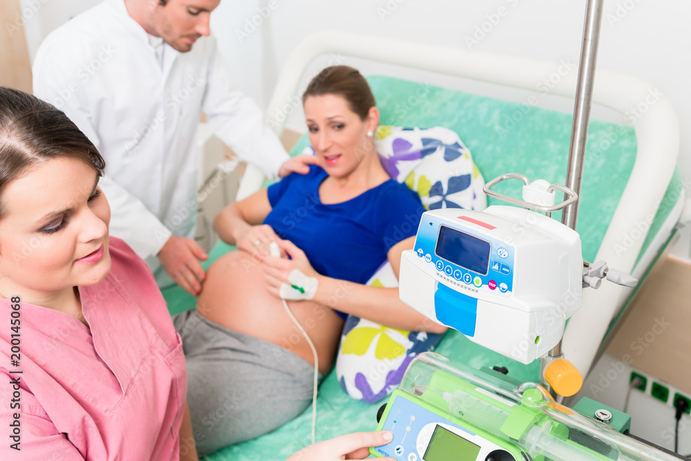Pregnant woman in delivery room of hospital with doctor and nurse Stock ...