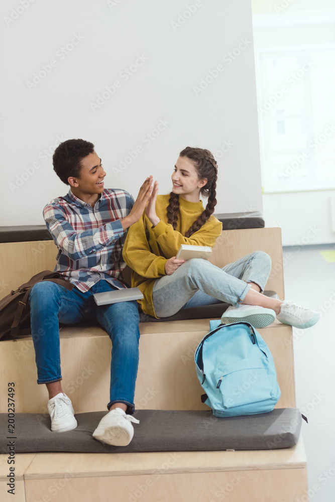 high school students couple sitting together at school corridor and ...