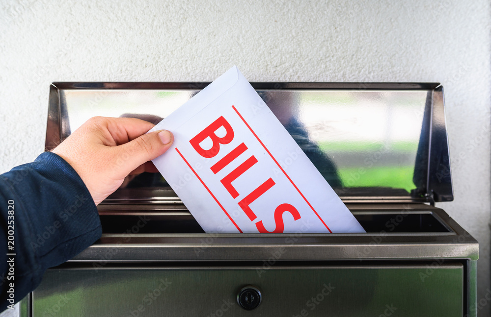 Bills. Hand putting letter with word bills in mailbox Stock Photo ...