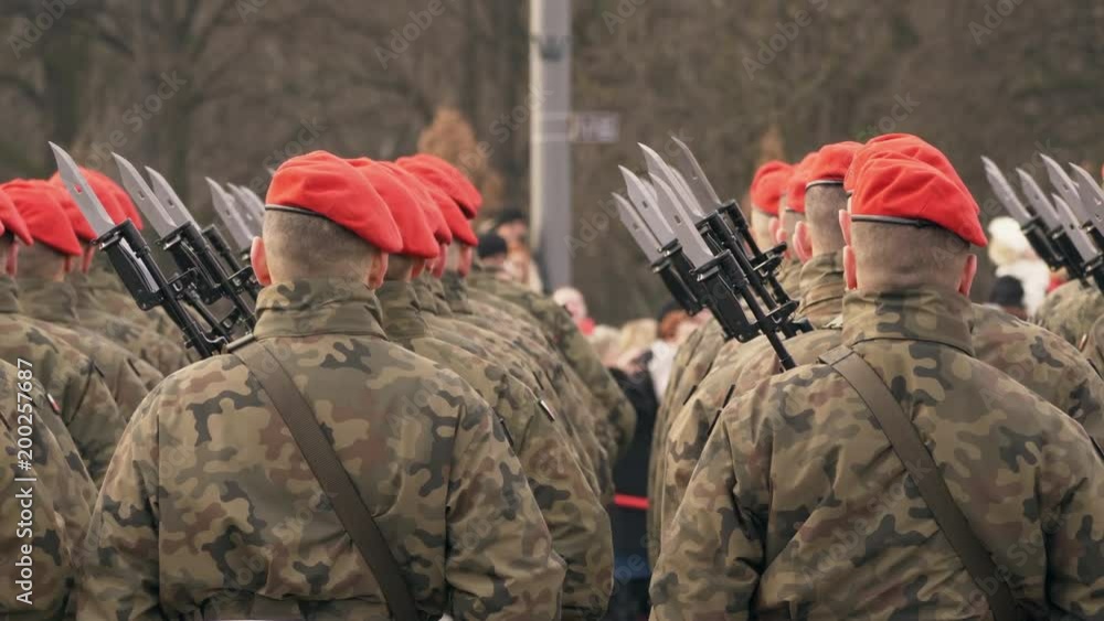 A lot of soldiers in red berets and green uniform stand with their ...