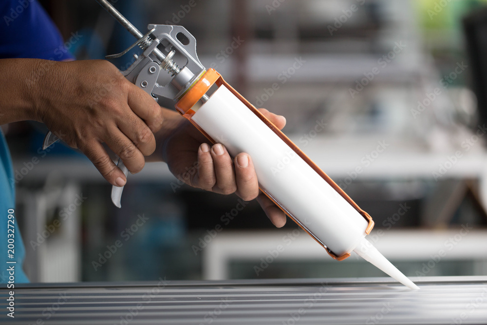 Construction workers installing windows and using silicon Stock Photo ...