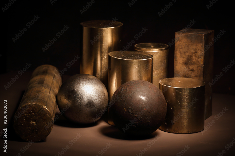 Metal parts of cylindrical and spherical shape on a black background ...