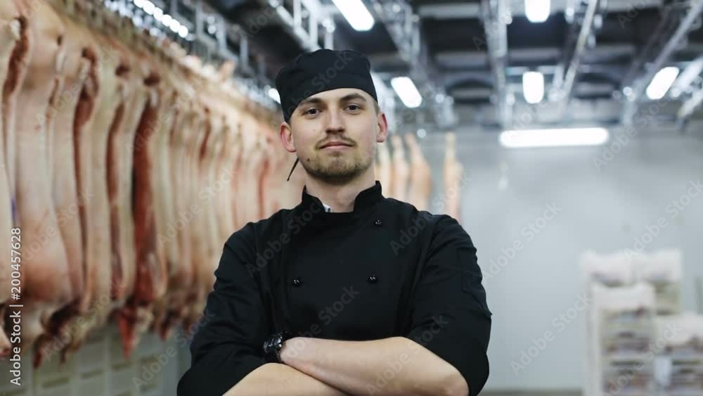 Vidéo Stock Portrait of handsome young smiling butcher in black uniform ...