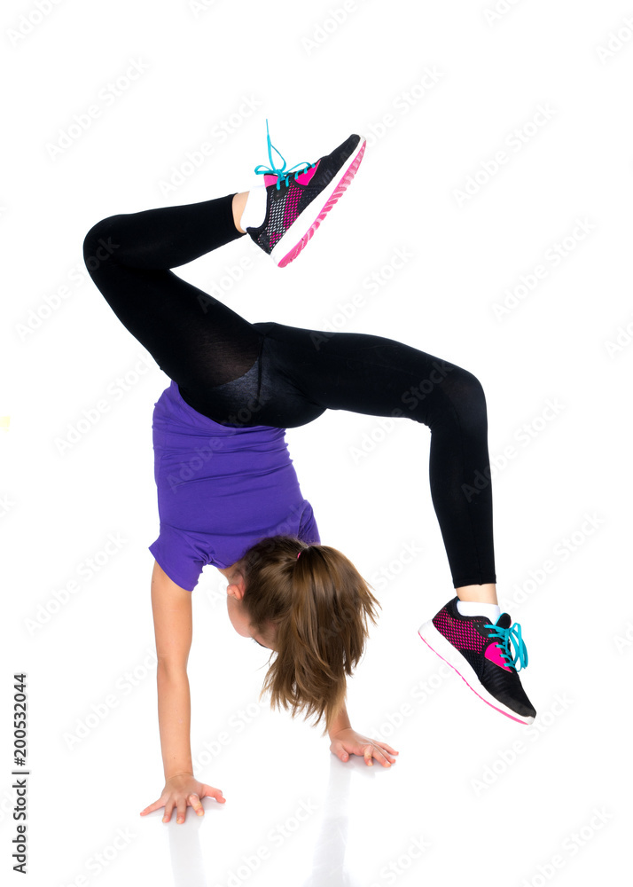 The gymnast performs a handstand with bent legs. Stock Photo | Adobe Stock