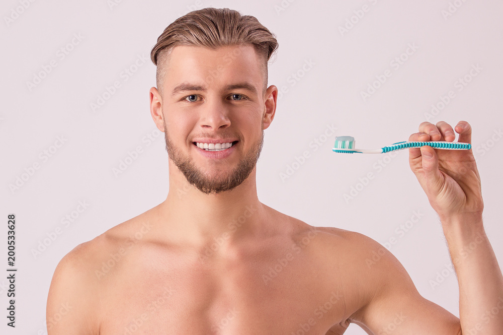 Portrait of young handsome man looking to camera and smiling while ...