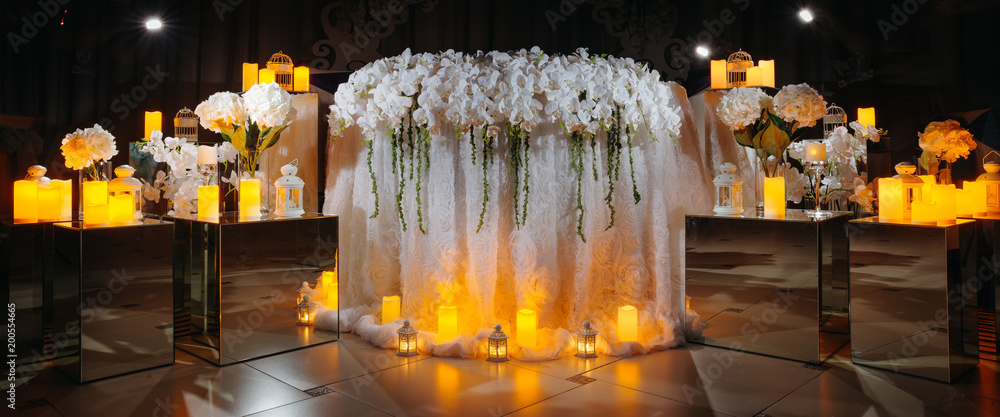 Wedding table of the newlyweds decorated with candles on a black ...