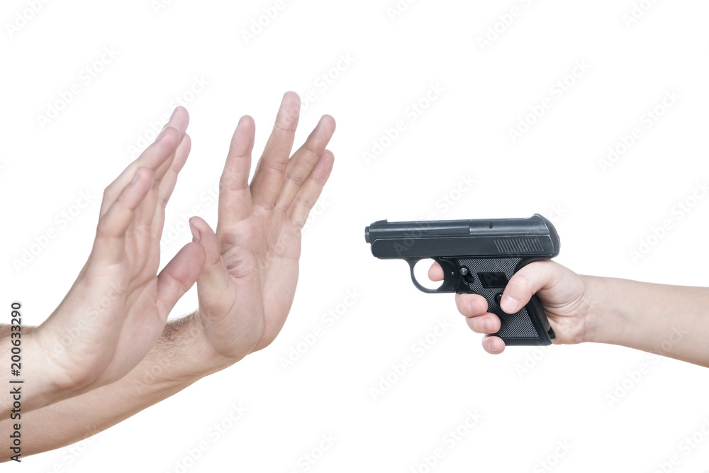 Child hand with a gun aiming at the male hands showing a stop isolated ...