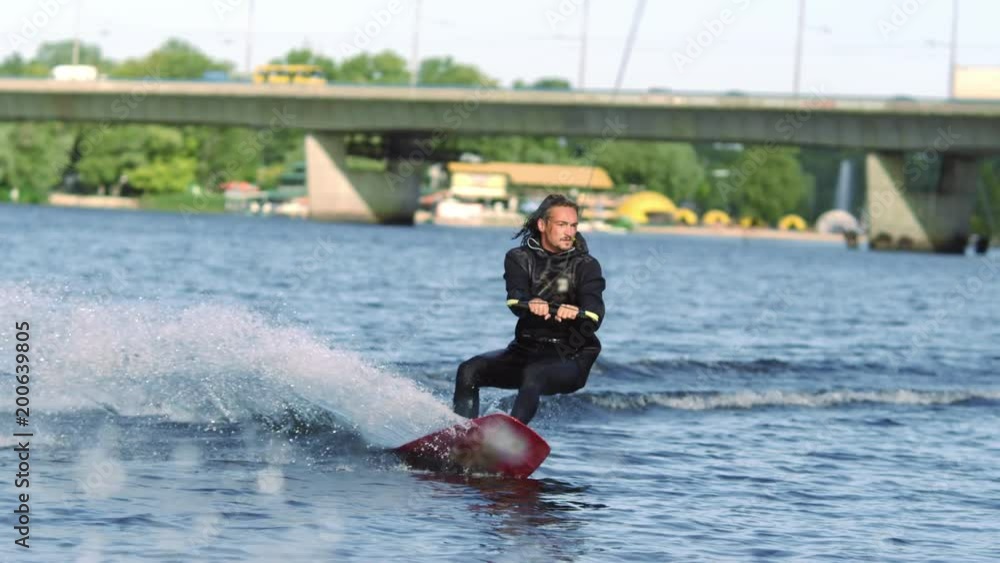 Wakeboarder jumping high above water. Professional sportsman making ...