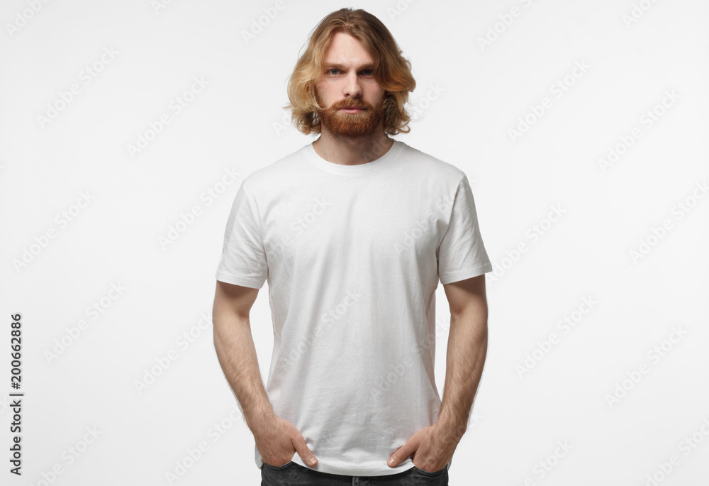 Young european masculine man standing with hands in pockets, wearing ...