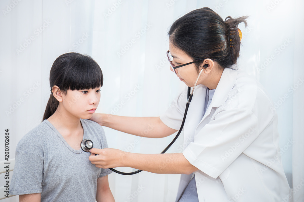 Young asian girl at the doctor's clinic. Asian doctor woman examining ...
