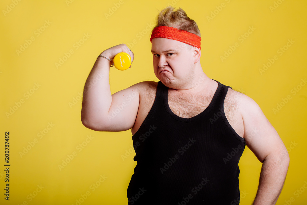 Fat man shows his muscle while holding dumbbell in hand Stock Photo ...