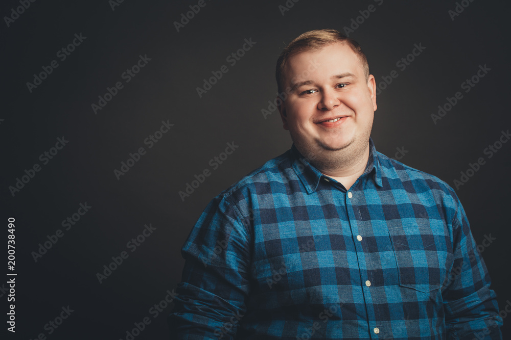 Portrait of smiling fat man on black background Stock Photo | Adobe Stock