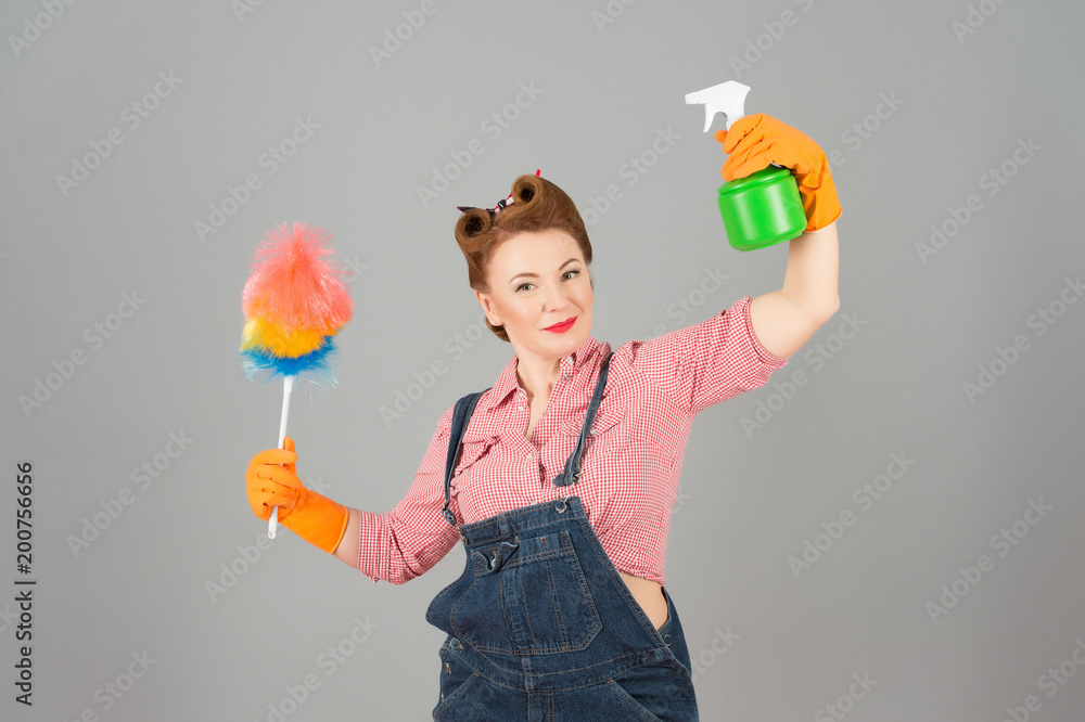 Girl in pin up styled with soft colorful duster and green spray bottle ...