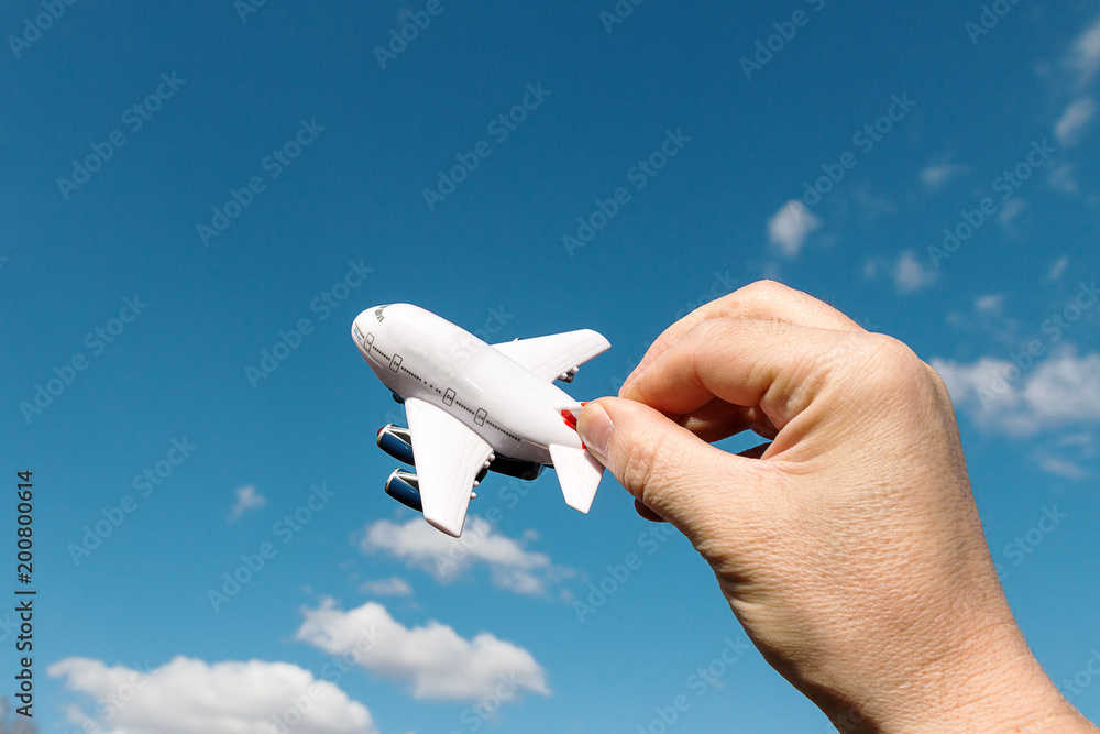 model of passenger airplane in hand on blue sky Stock Photo | Adobe Stock