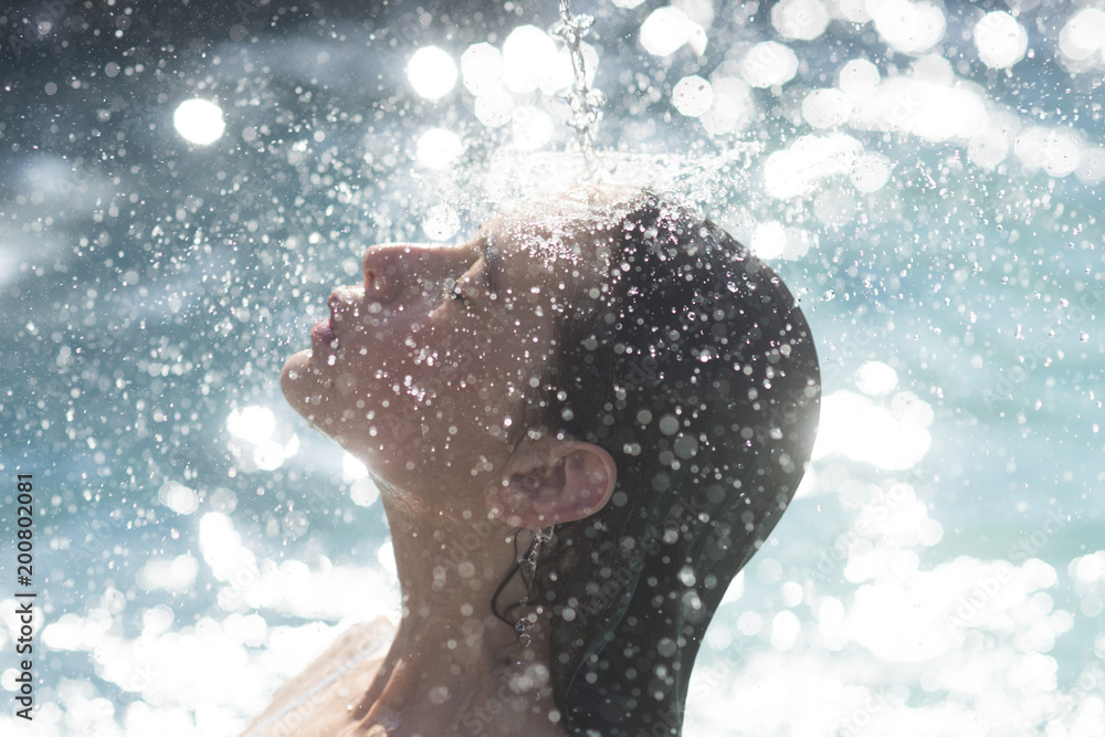 water drops on face of young woman. water bathing in swimming pool ...