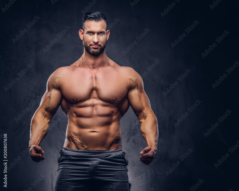 Portrait of a shirtless tall huge male with a muscular body with a ...