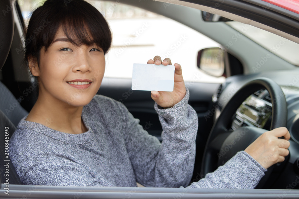 Attractive young asian woman proudly showing her drivers license ...