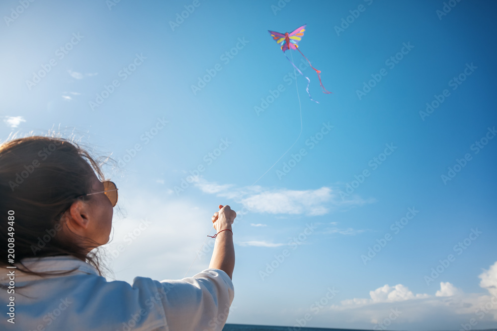 Beautiful young woman launches a kite in the blue sky Stock Photo ...