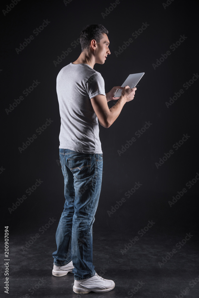 Digital technology. Smart pleasant confident man standing against black ...
