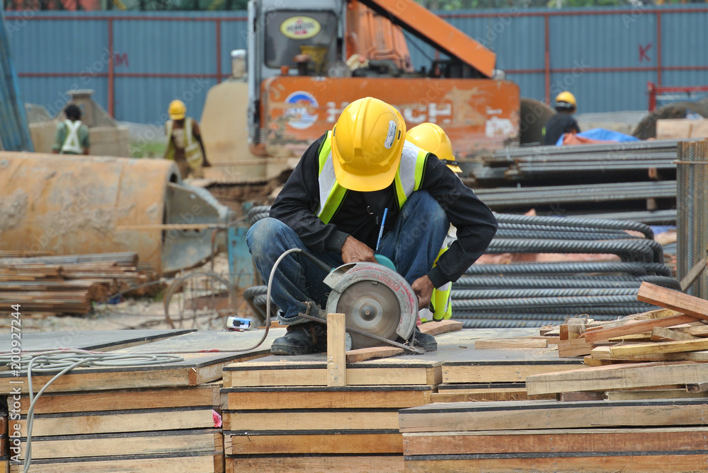 Carpenter using electrical powered circular saw to cut wood at the ...
