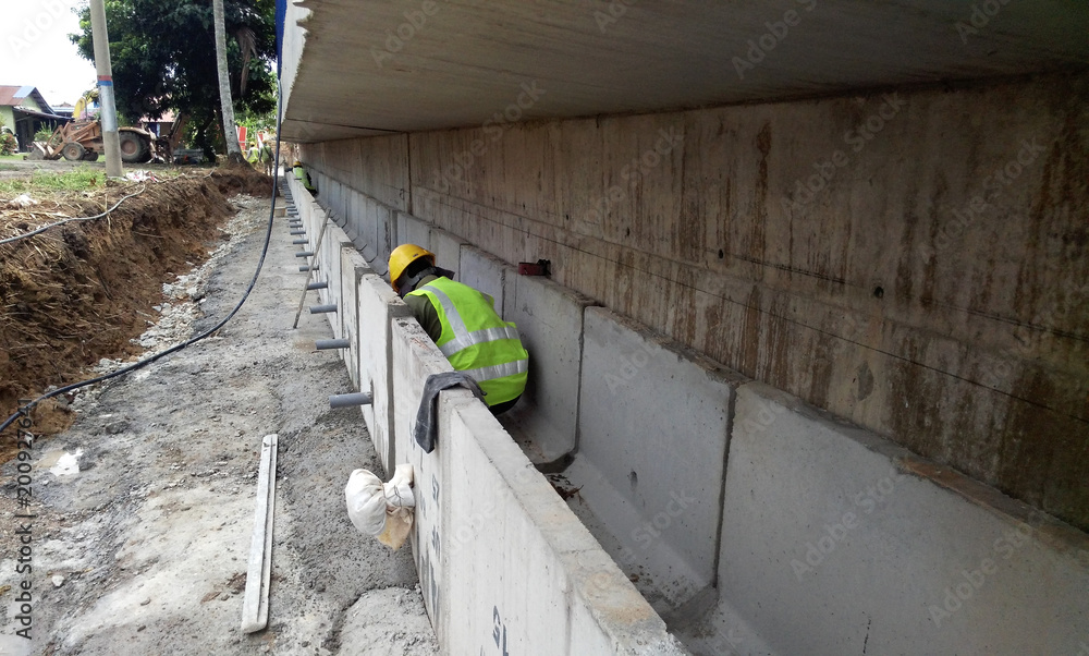 Construction workers installing precast concrete drain at the ...