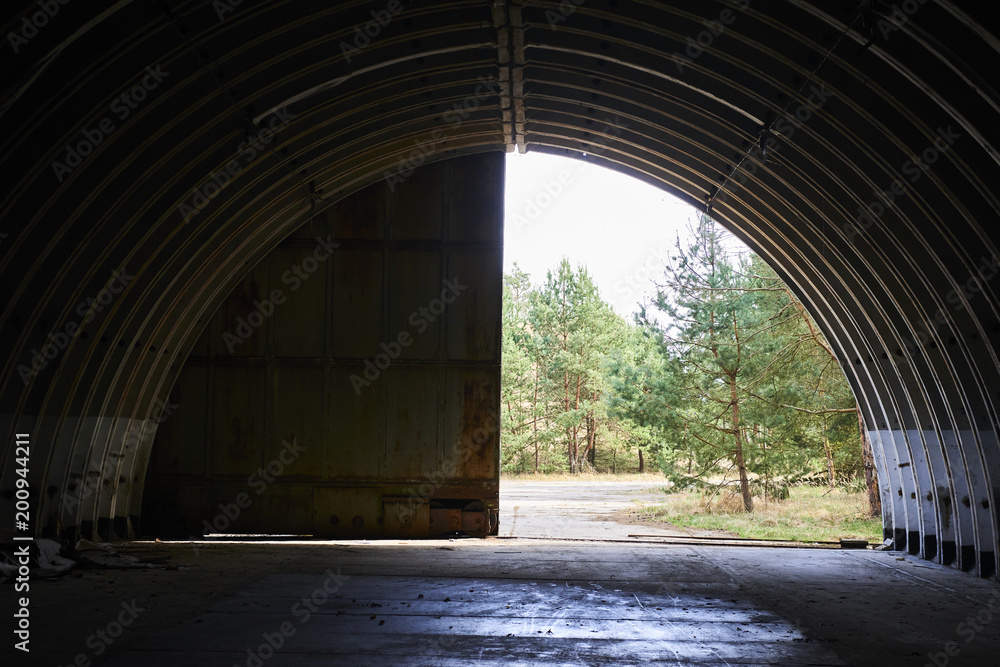Interior of abandoned old military hangar for storage and maintenance ...