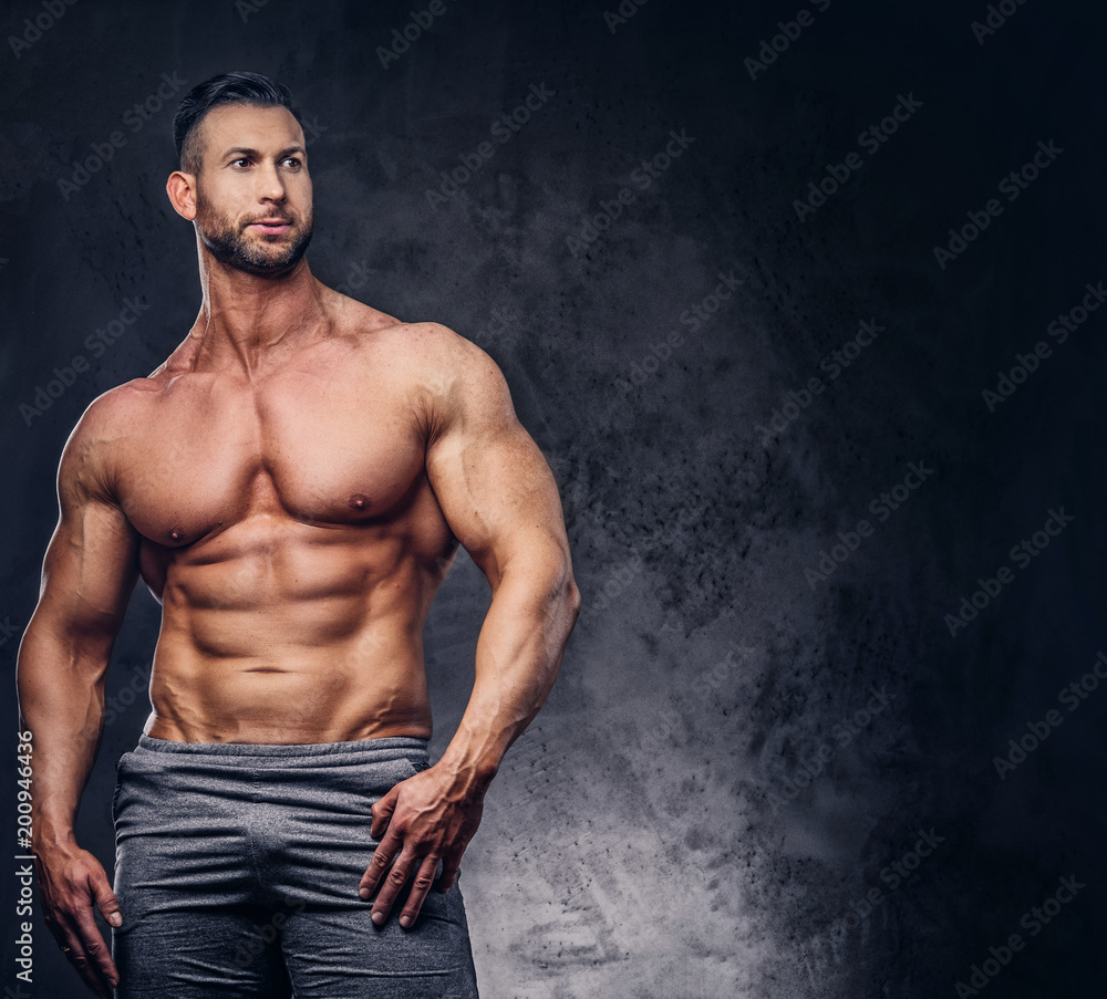Portrait of a shirtless tall huge male with a muscular body with a ...