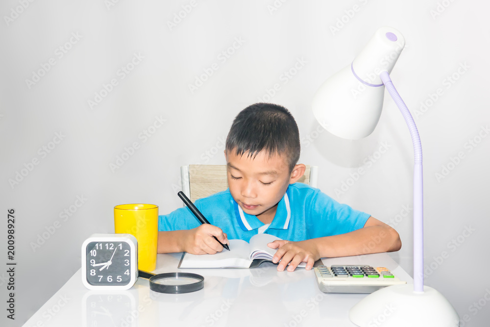 Soft cute child writing and working on work desk. Asian child boy is ...