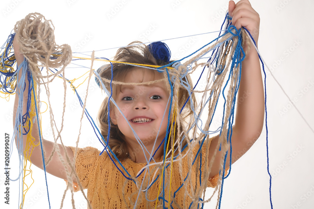 little girl holding tangled yarn of wool for knitting in her hands ...