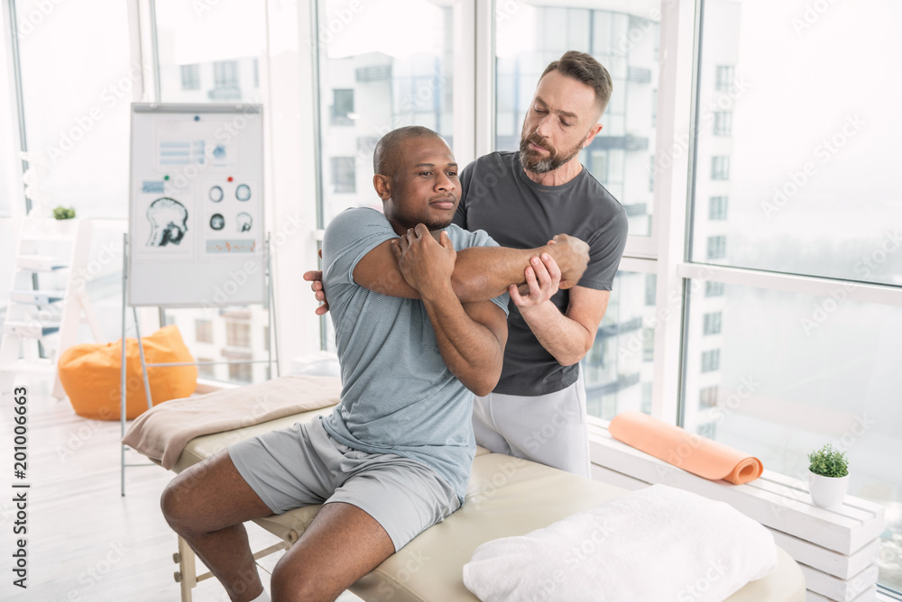 Professional therapy. Pleasant good looking man moving his body while ...