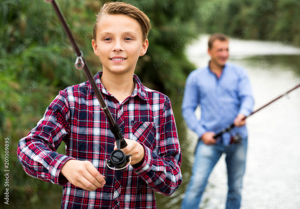 Boy fishing using rod from water side Stock Photo | Adobe Stock